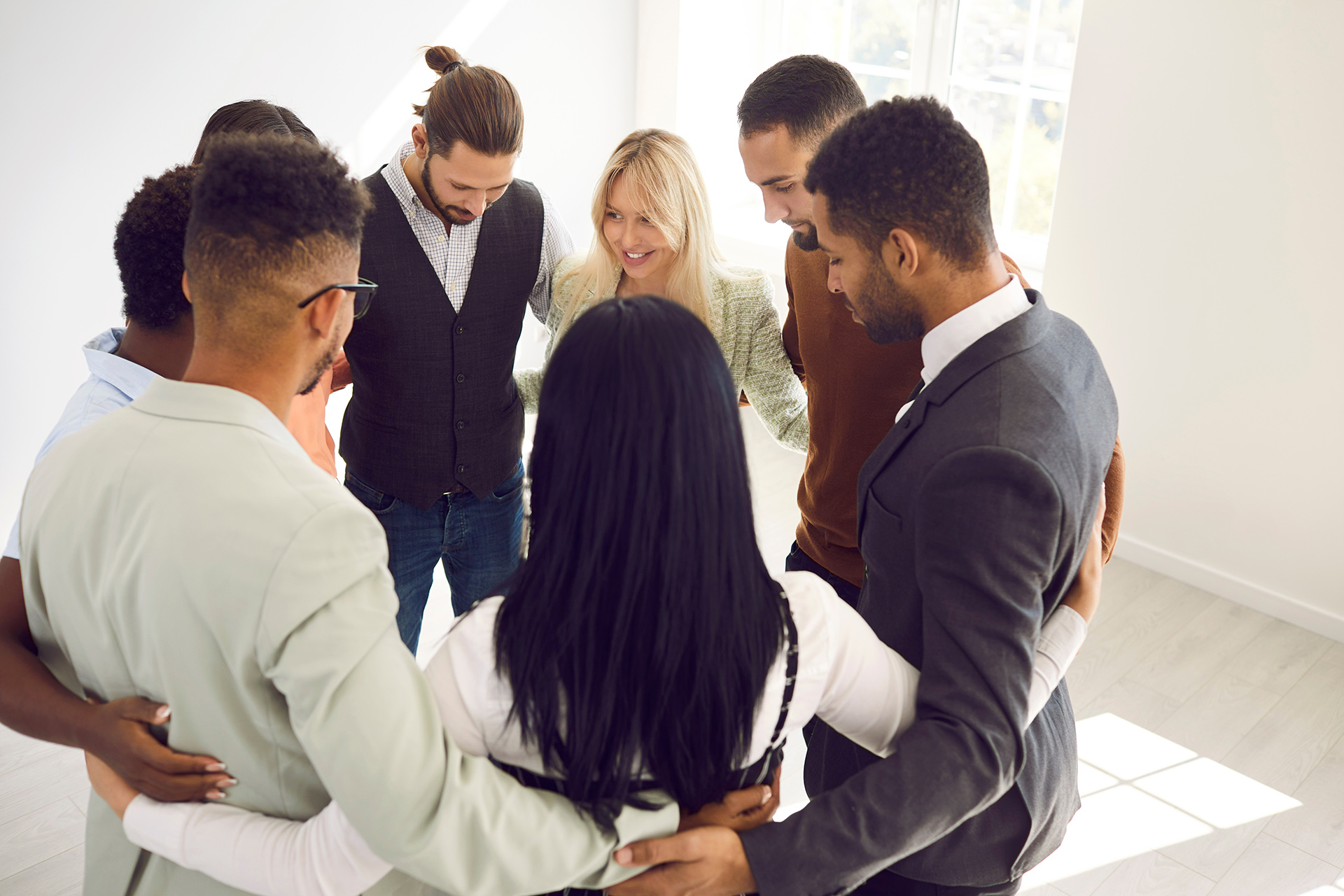 Diverse team of happy young business people standing in office and ...